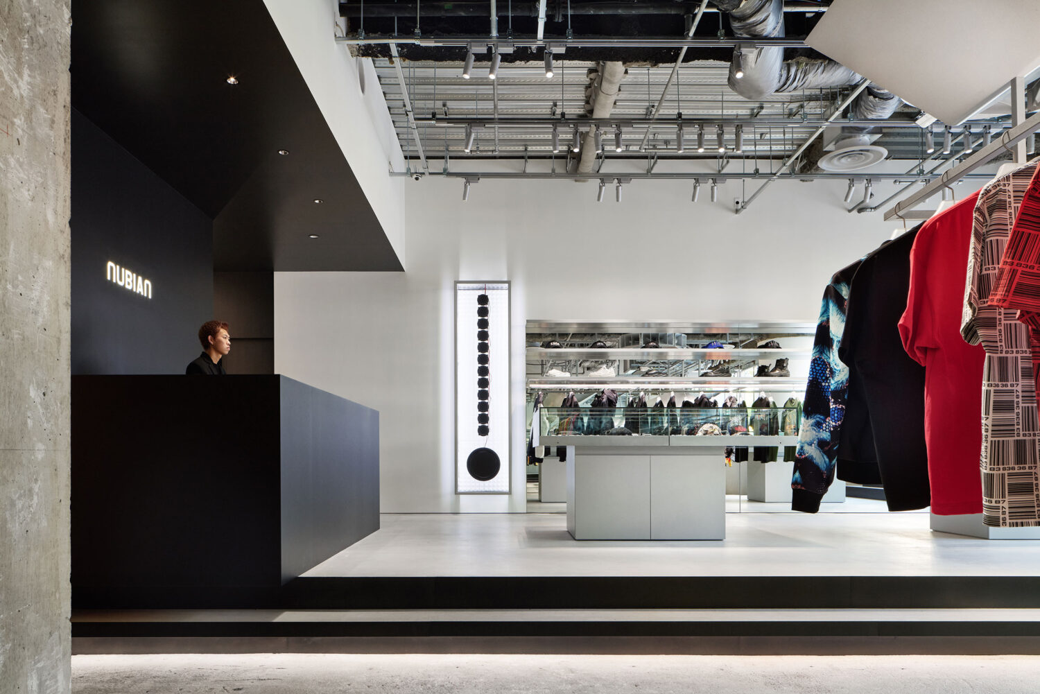 トラフによる、名古屋市の店舗「NUBIAN NAGOYA PARCO」。商業施設の内と外に入口がある区画に計画。環境条件の空間演出への援用を目指し、内では視界を絞り入店体験を設計して外では高低 ...
