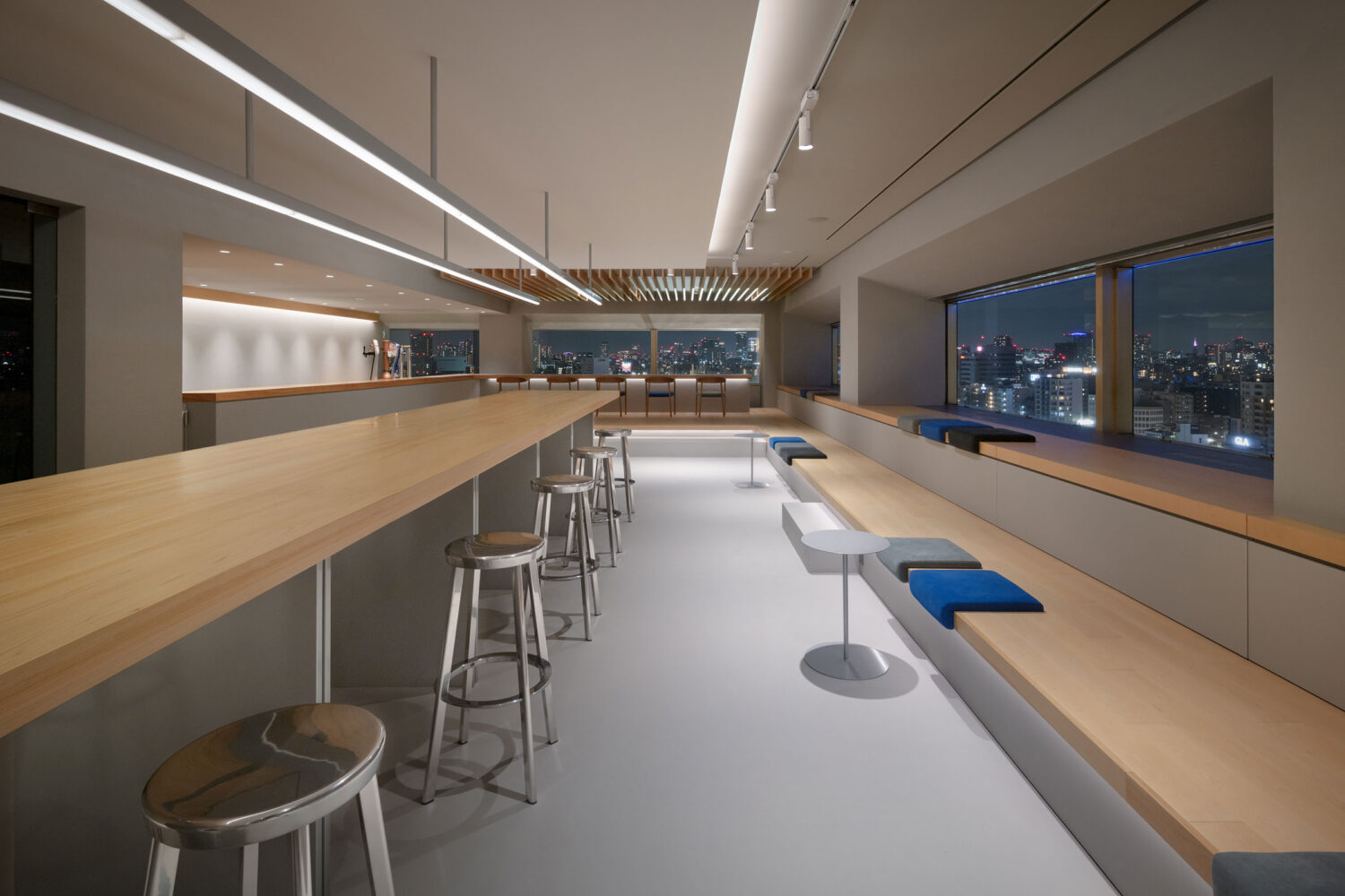 ODS / 鬼木孝一郎による、東京・墨田区の、社屋内ラウンジ「Asahi Terrace」。特徴的な外観で知られる建築内に計画。水平連続窓からの景色を楽しめる空間を目指し、窓高に揃えたベンチ等 ...