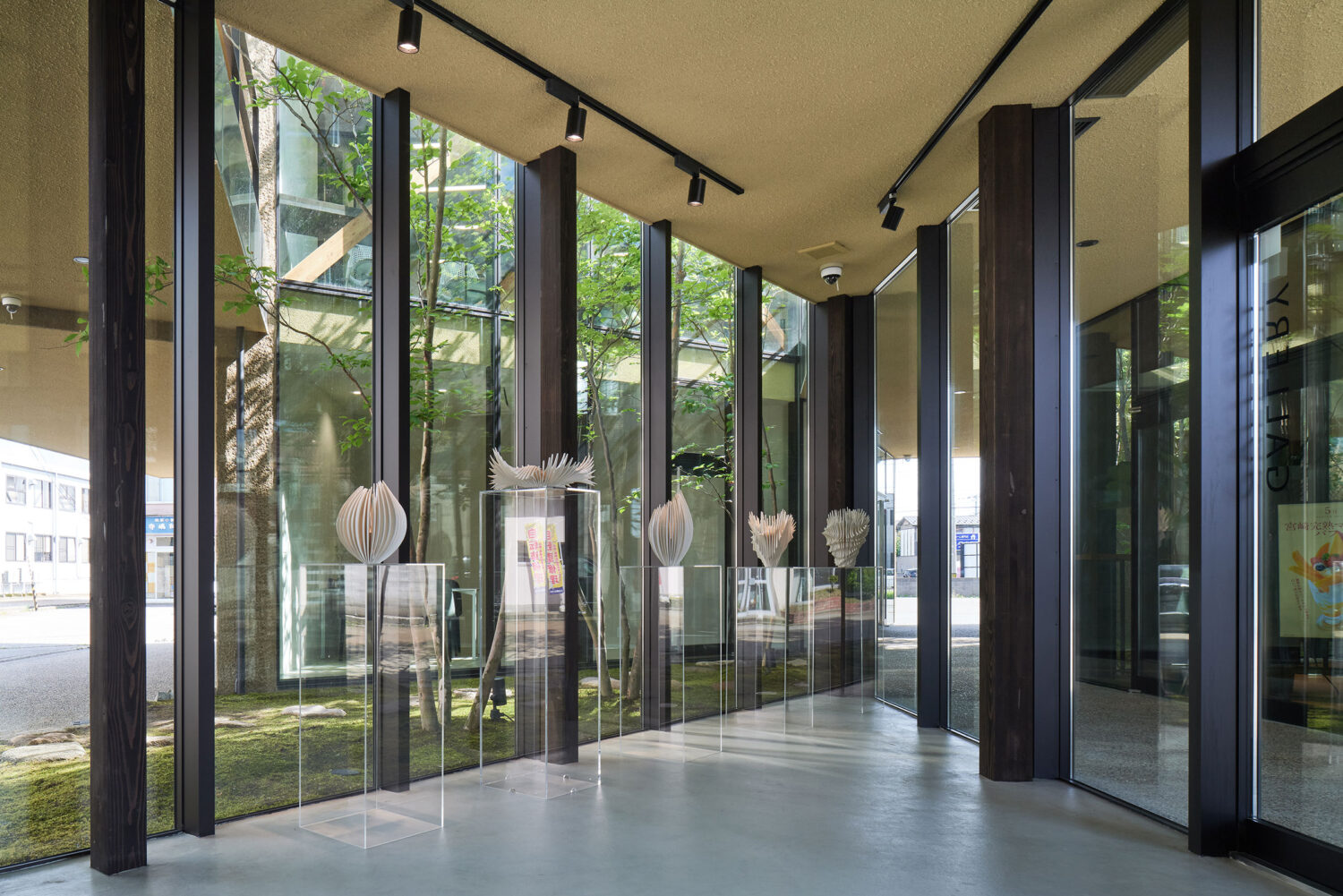 奈良祐希 / EARTHENによる、石川・金沢市の「Node Kanazawa」。カフェ等も内包する建築企業の新社屋。賑わいの創出等の地域社会への貢献も求め、周辺と繋がる“緑のミチ”と“街の ...